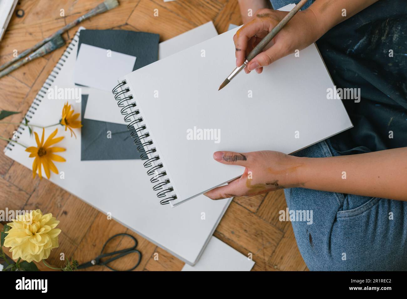 Overhead view of an artist sitting on the floor ready to paint with ...