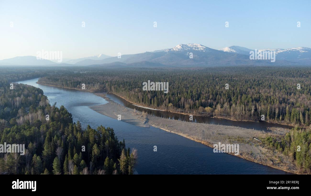 Aerial view of mountain river in taiga. Forest in early spring in ...
