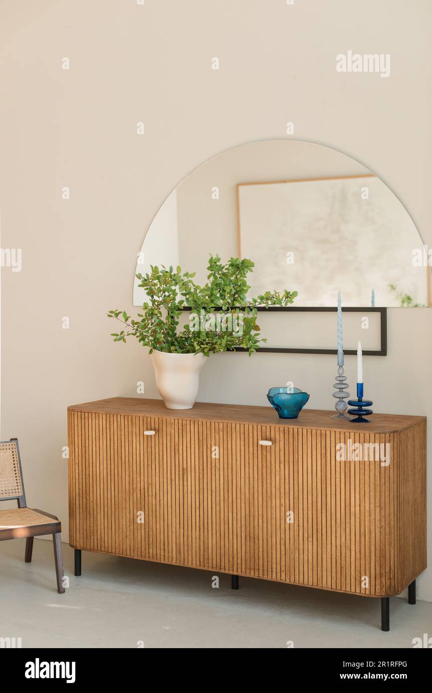 Candlesticks, bowl and green branches in vase on a modern sideboard in ...