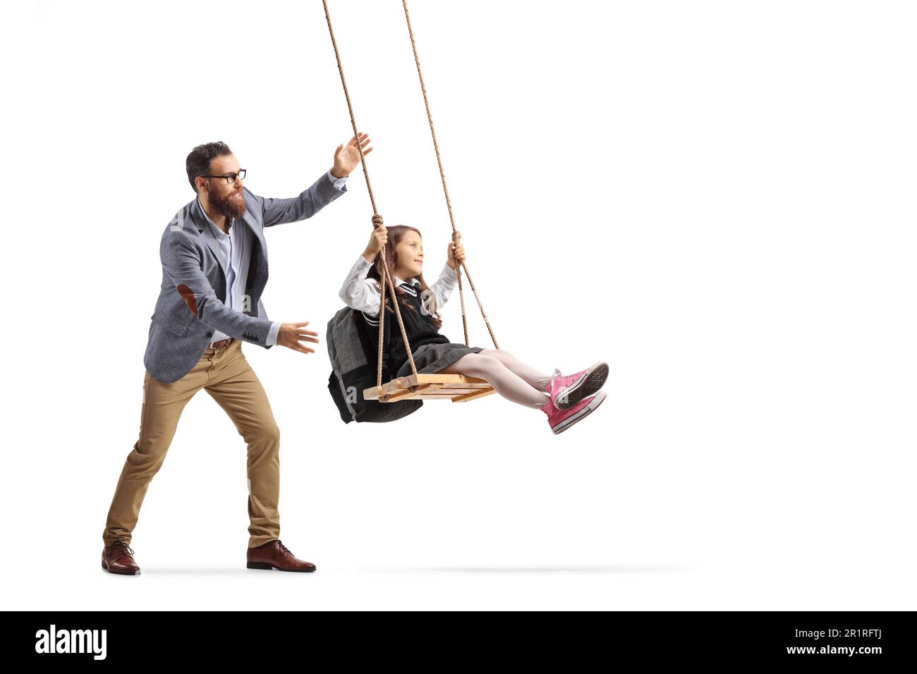 Full length shot of a man pushing a schoolgirl on a swing isolated on ...