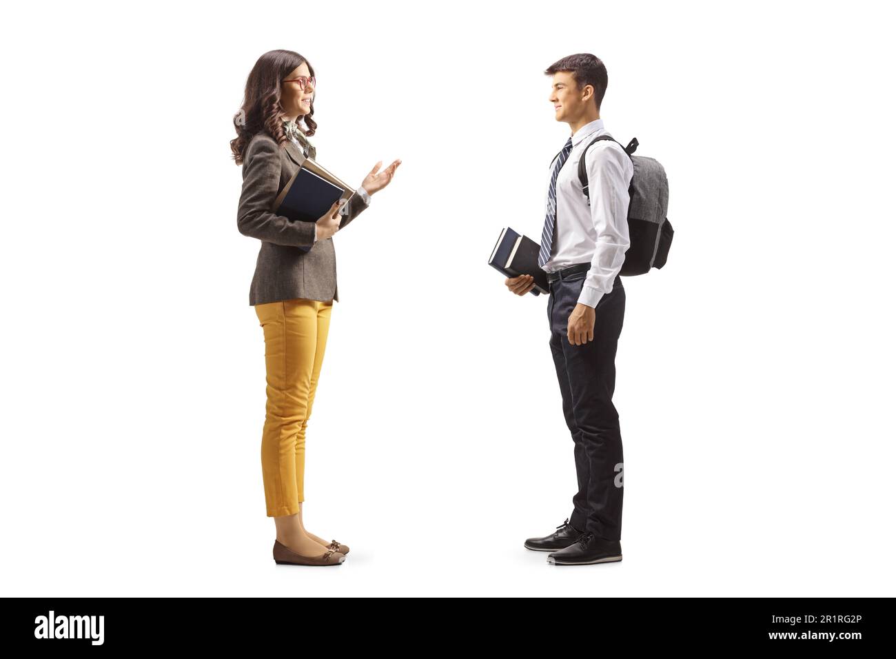 Full length profile shot of a young teacher talking to a male teenage ...
