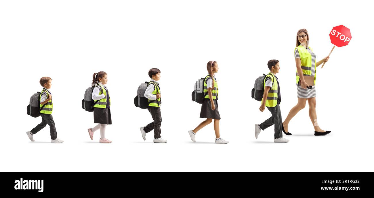 Female teacher leading schoolchildren in safety vests, carrying a stop ...