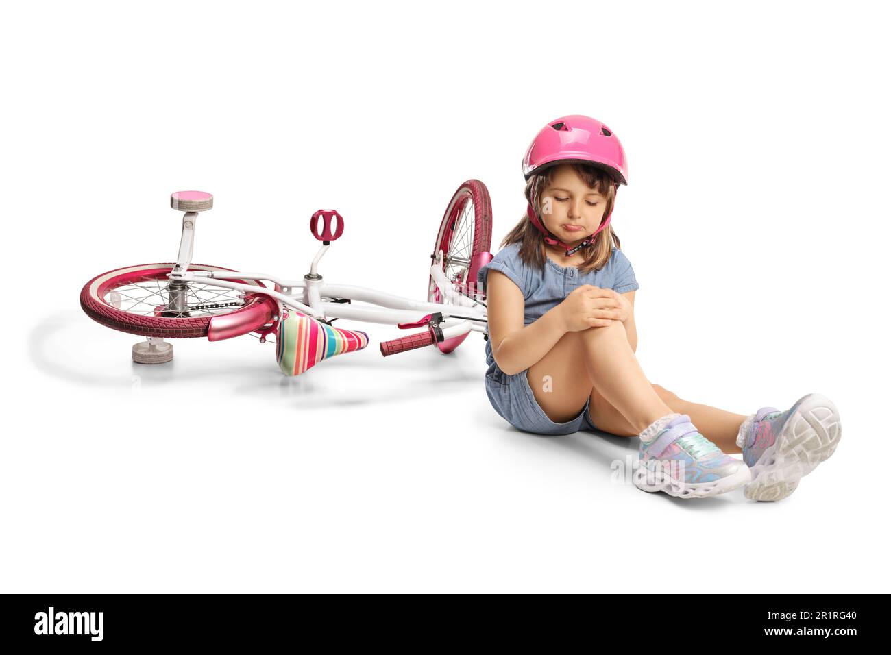 Sad girl with a bicycle holding her injured knee and sitting on the ...