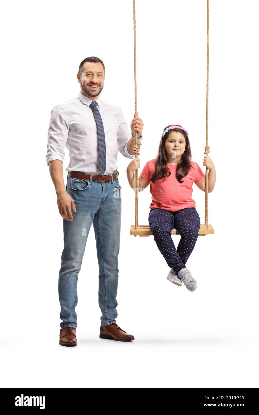 Full length portrait of a father standing next to a daughter on a swing ...