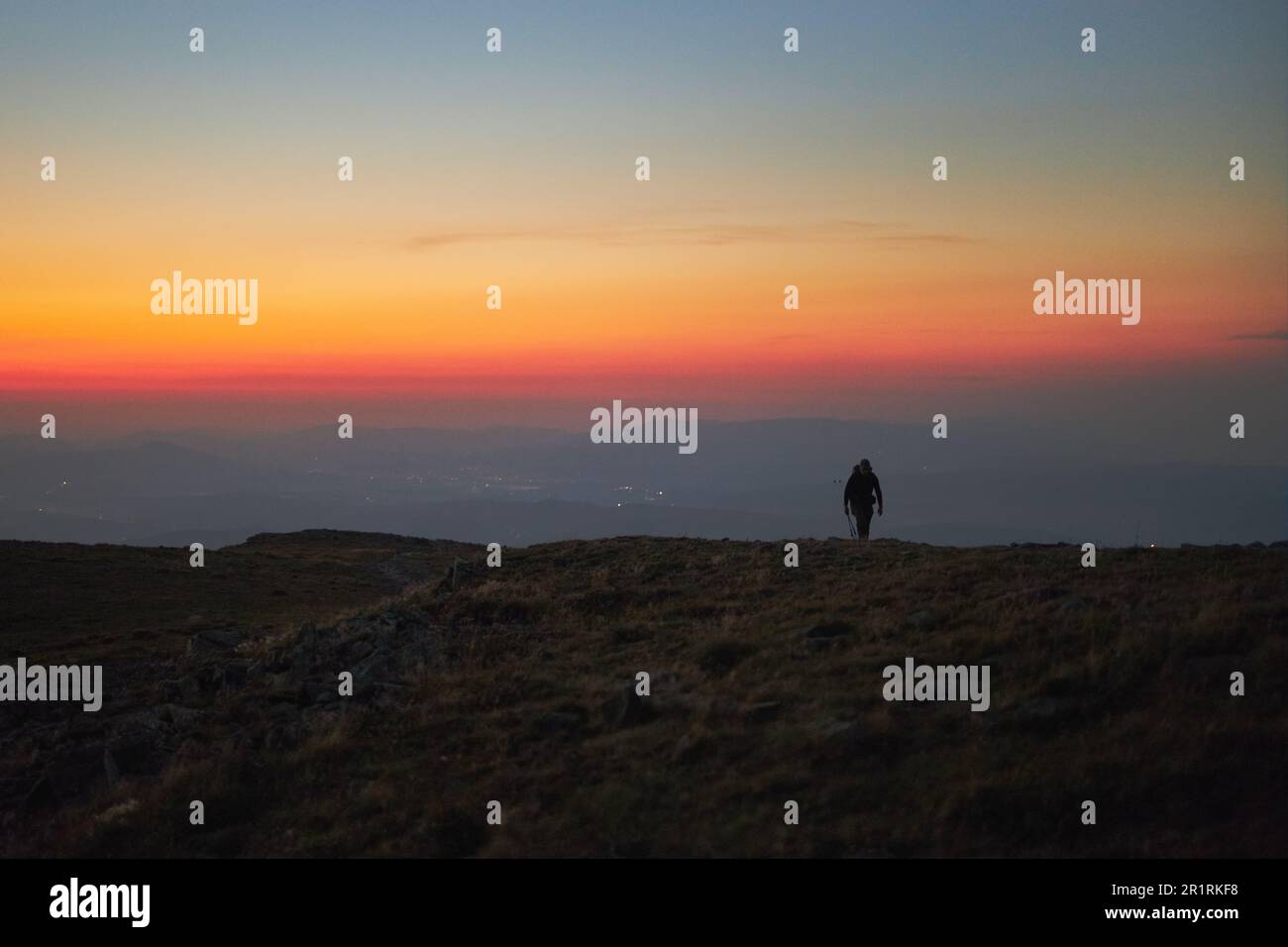 Man looking at sunrise. Mountains at sunrise. Man standing on peak ...