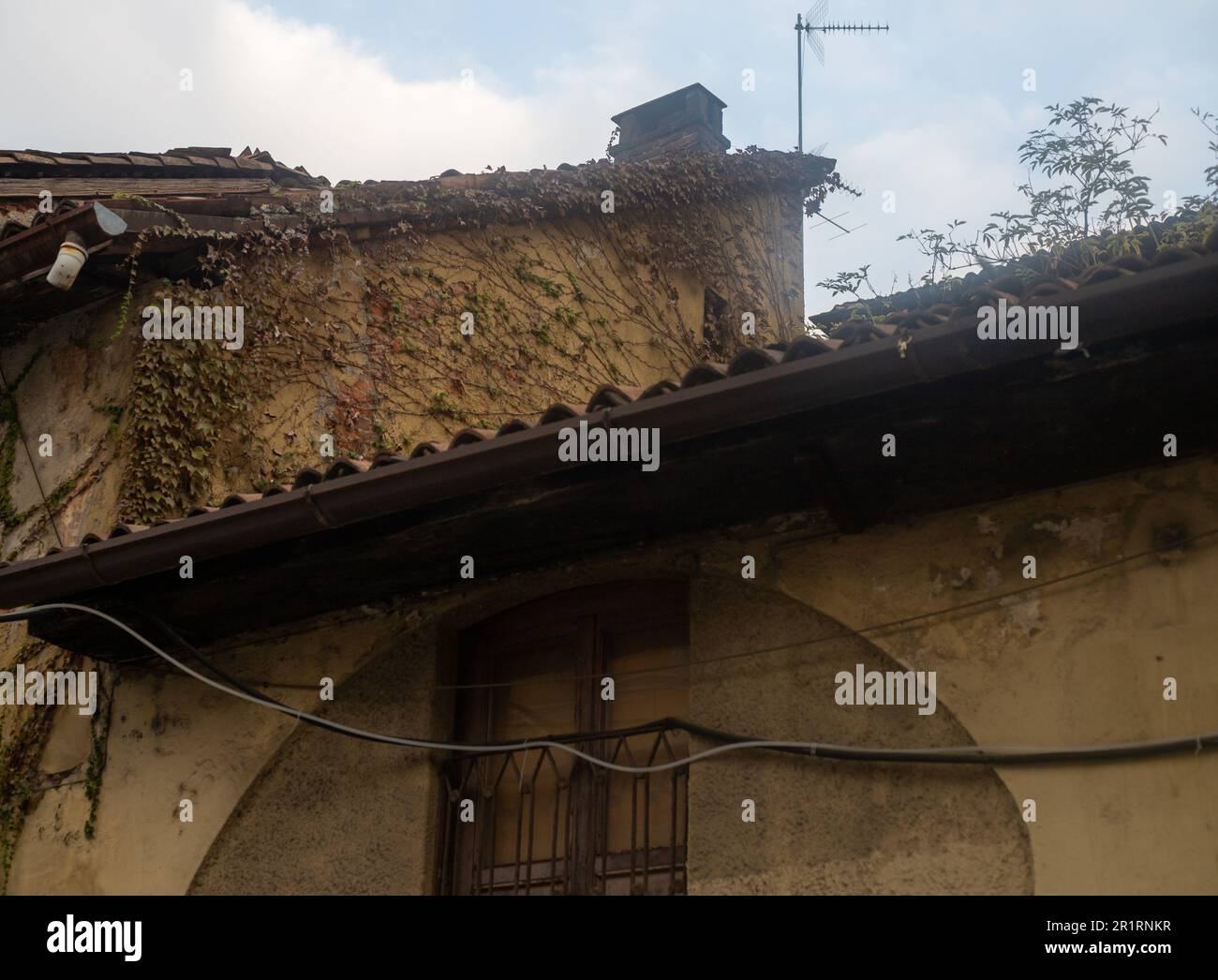 A derelict, abandoned building with ivy cascading over the roof Stock ...