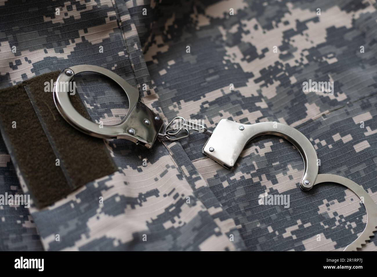 Handcuffs on a Camouflage background. Metal shackles isolated. Law ...