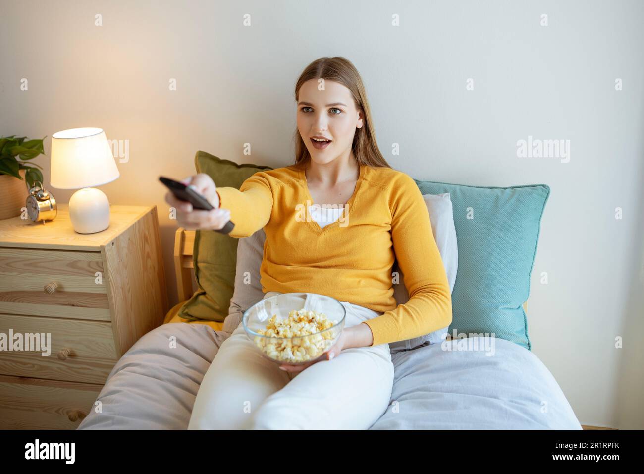 Young Lady Watching Television Enjoying Favorite TV Shows In Bedroom ...