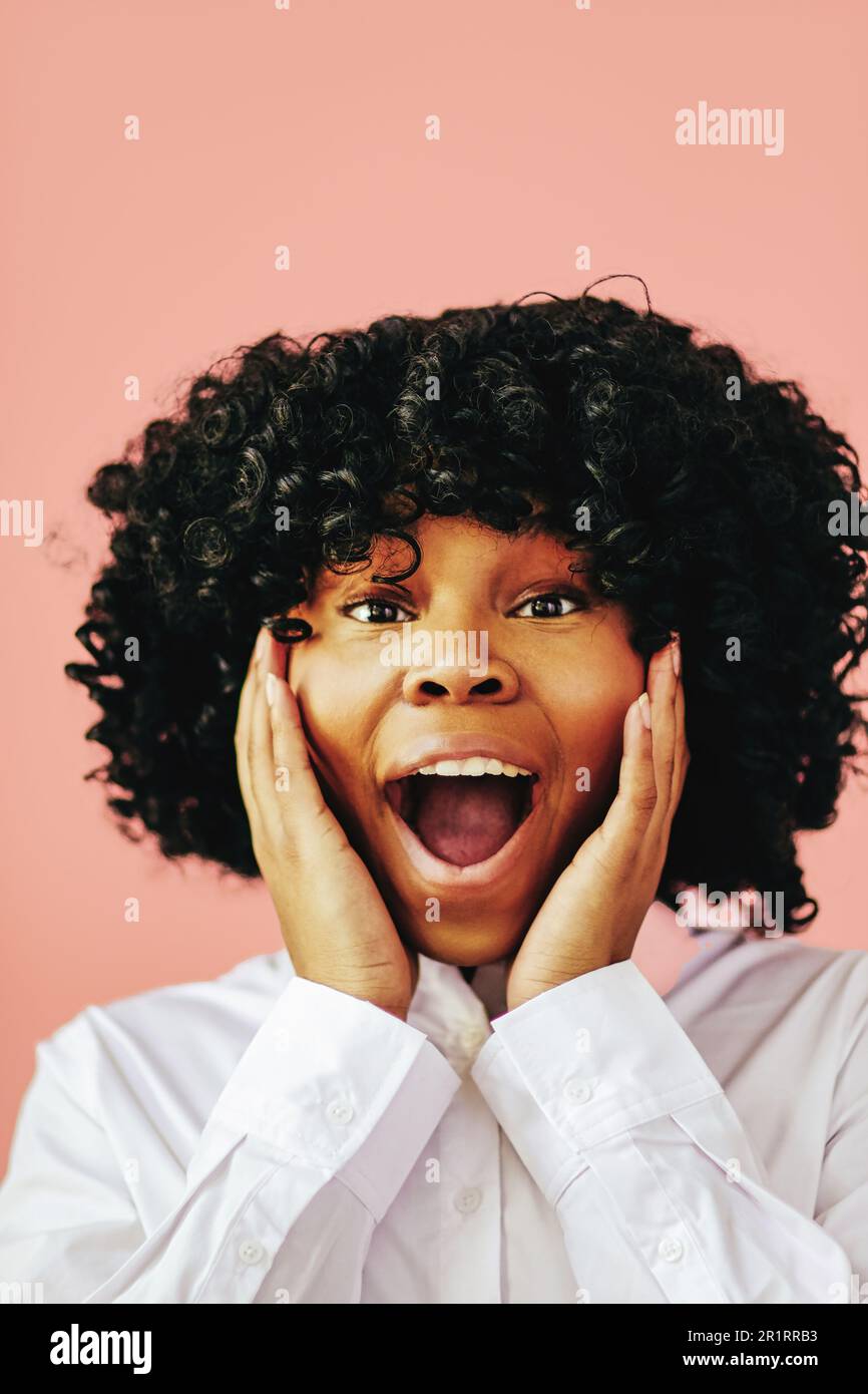 Close-up portrait of cheerful young adult black woman excited with open ...