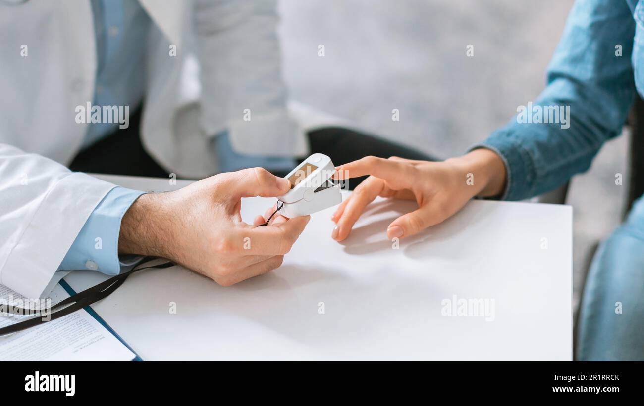 Breathing easy. Male doctor monitoring patient's health, measuring ...