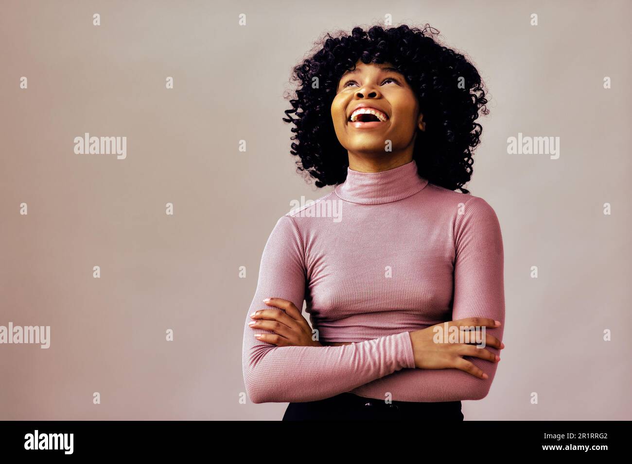 Millennial woman with arms crossed laughing, studio shot Stock Photo ...