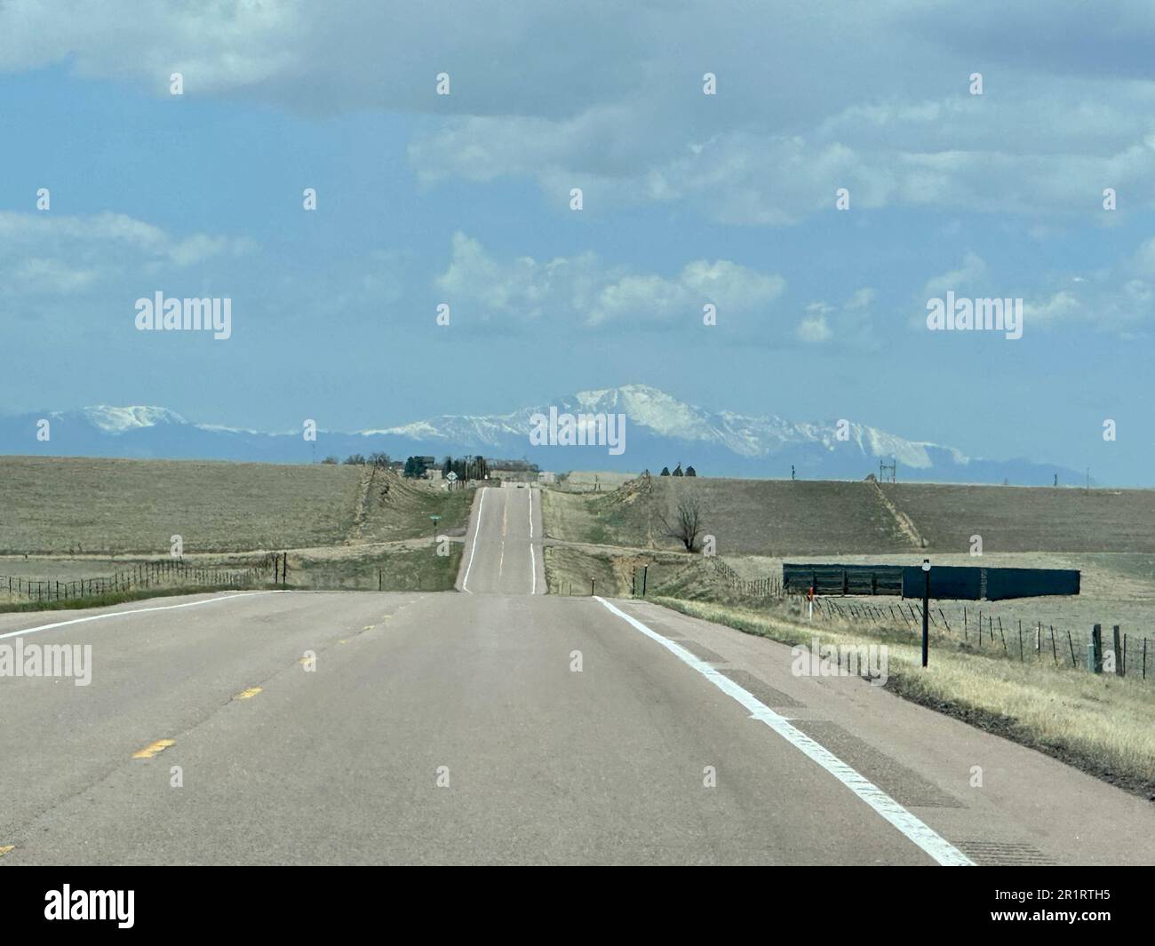 A long highway running through an expansive open field Stock Photo - Alamy