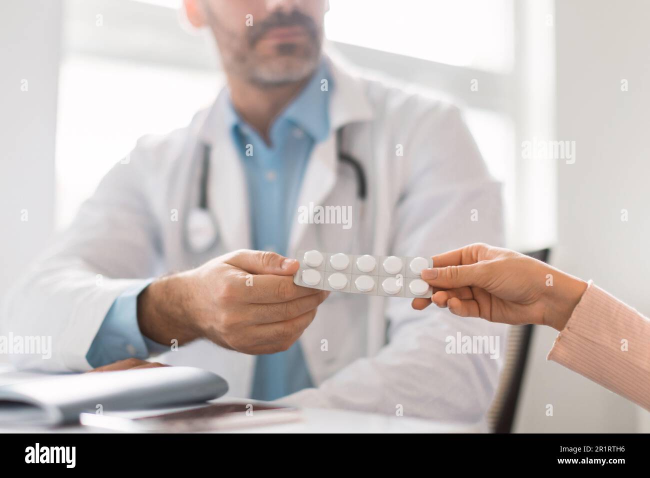 Male physician consulting female patient about pills, prescribing ...