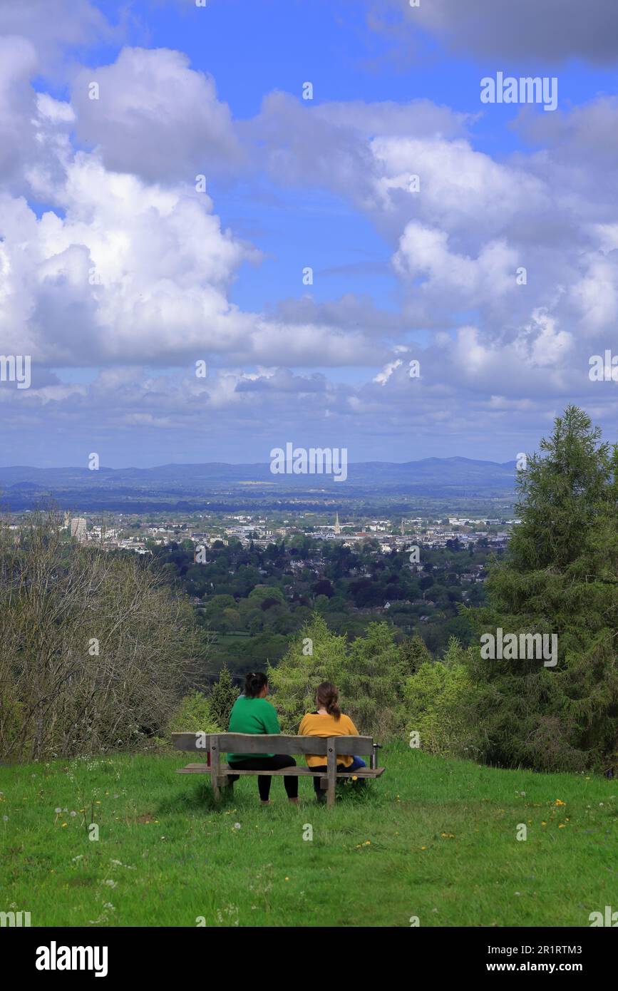 Two friends sitting on a bench with a stunning view overlooking ...