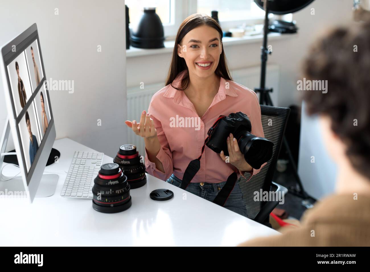 The art of feedback. Young photographer lady showing results of ...