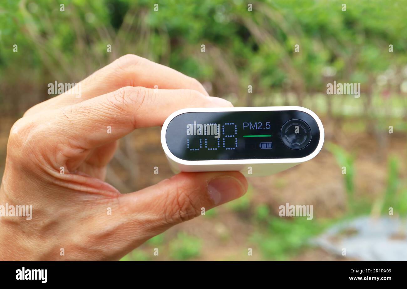 Man's hand holding an air pollution sensor measuring air quality in the ...