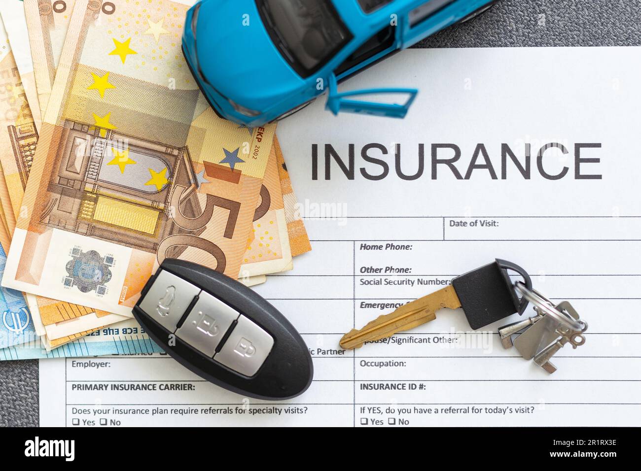 Top view of car insurance claim form with car key and car toy on desk ...