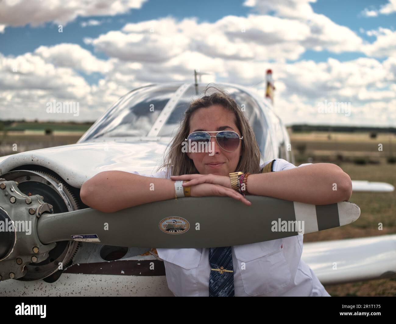 A blonde female pilot dressed in uniform posing near an airplane Stock ...