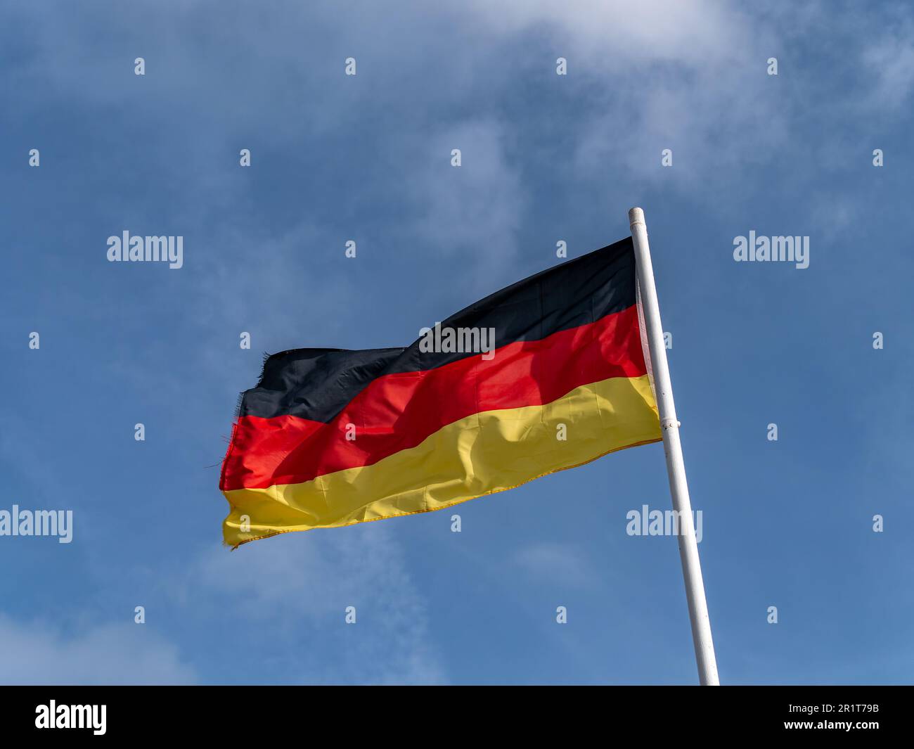 One German flag on a flagpole against a clear blue sky Stock Photo - Alamy