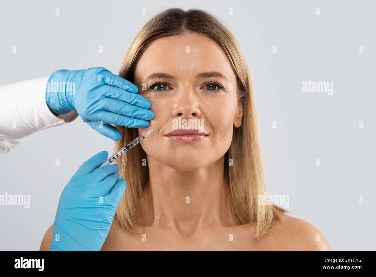 Beautiful middle aged woman getting cosmetic injection in nasolabial ...