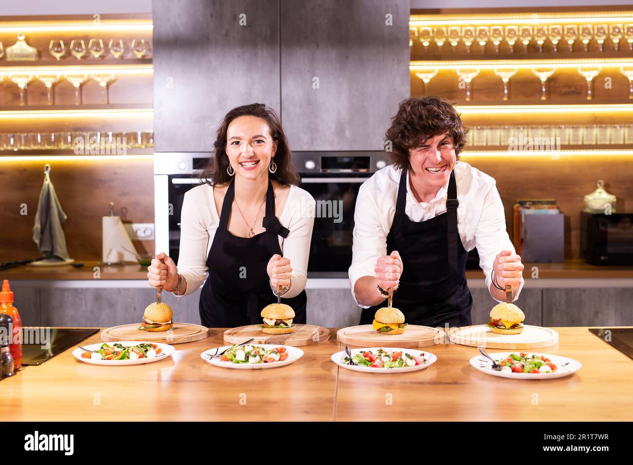 Funny chef and his colleague fooling around together at kitchen with ...