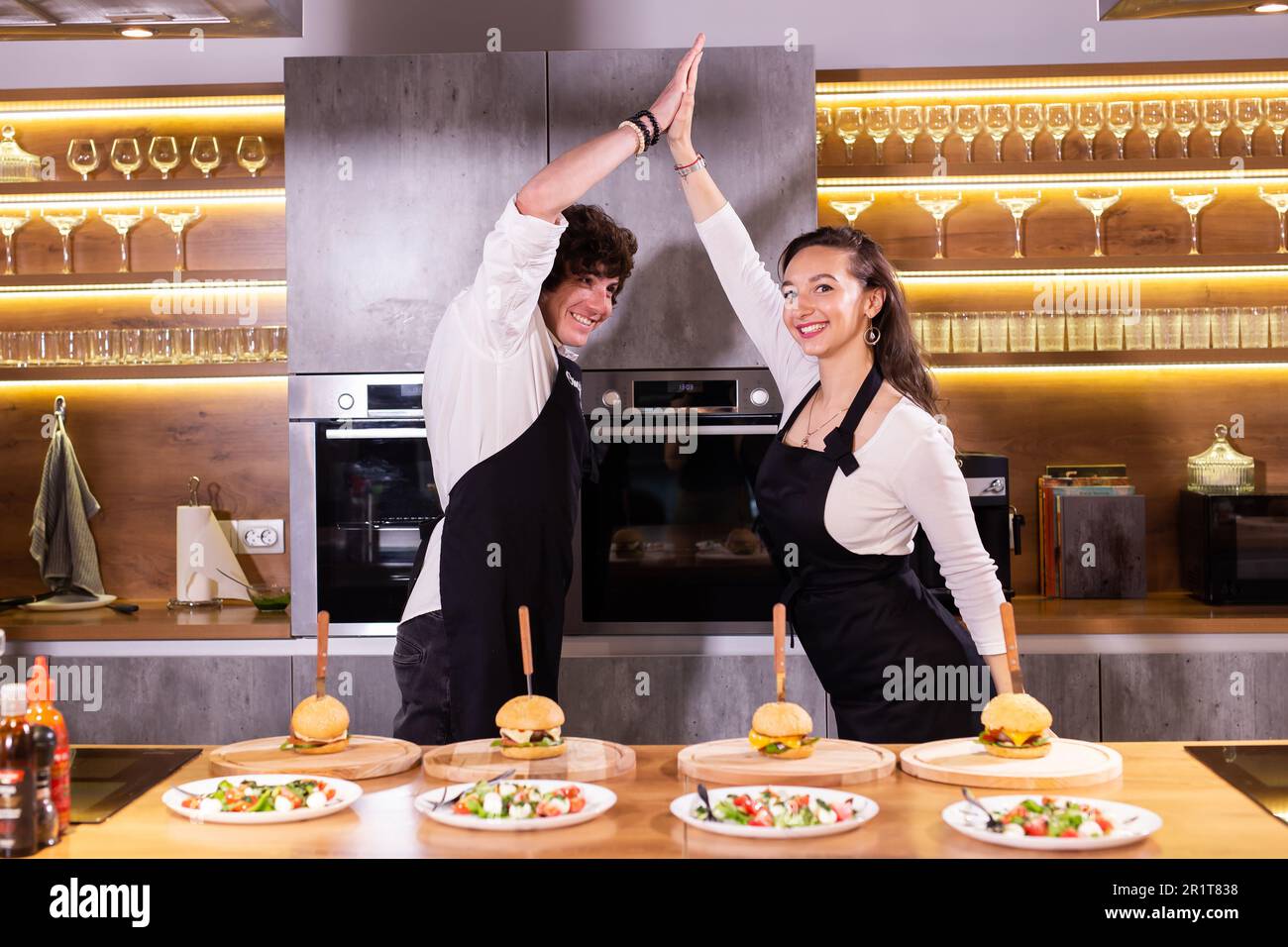 Funny chef and his colleague fooling around together at kitchen with ...