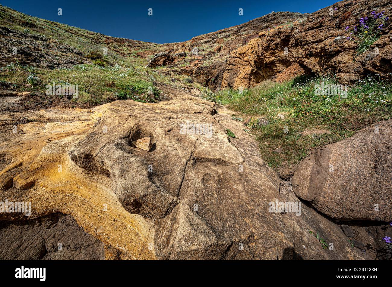 A scenic landscape featuring a steep cliffside with jutting rocks, lush ...