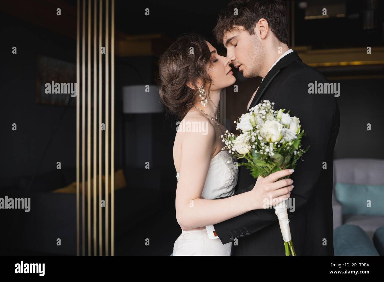 Side View Of Good Looking Groom In Black Formal Wear Kissing Brunette