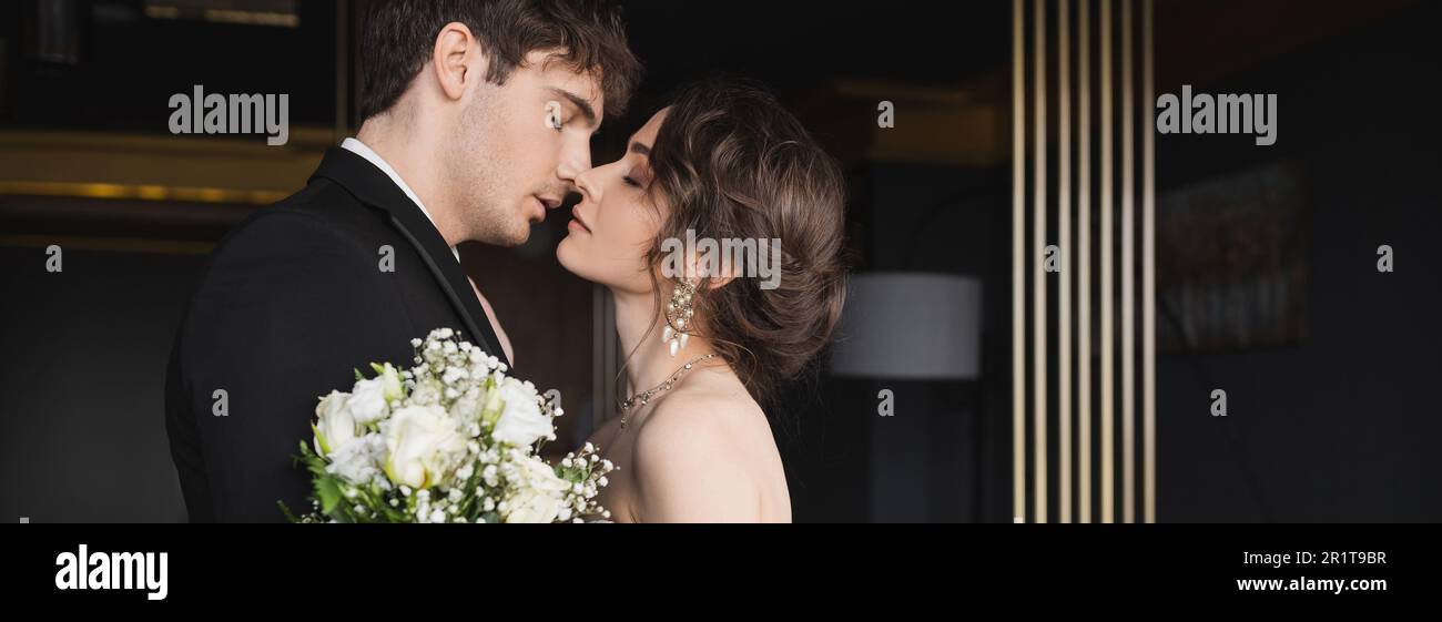 Side View Of Good Looking Groom In Black Formal Wear Kissing Brunette