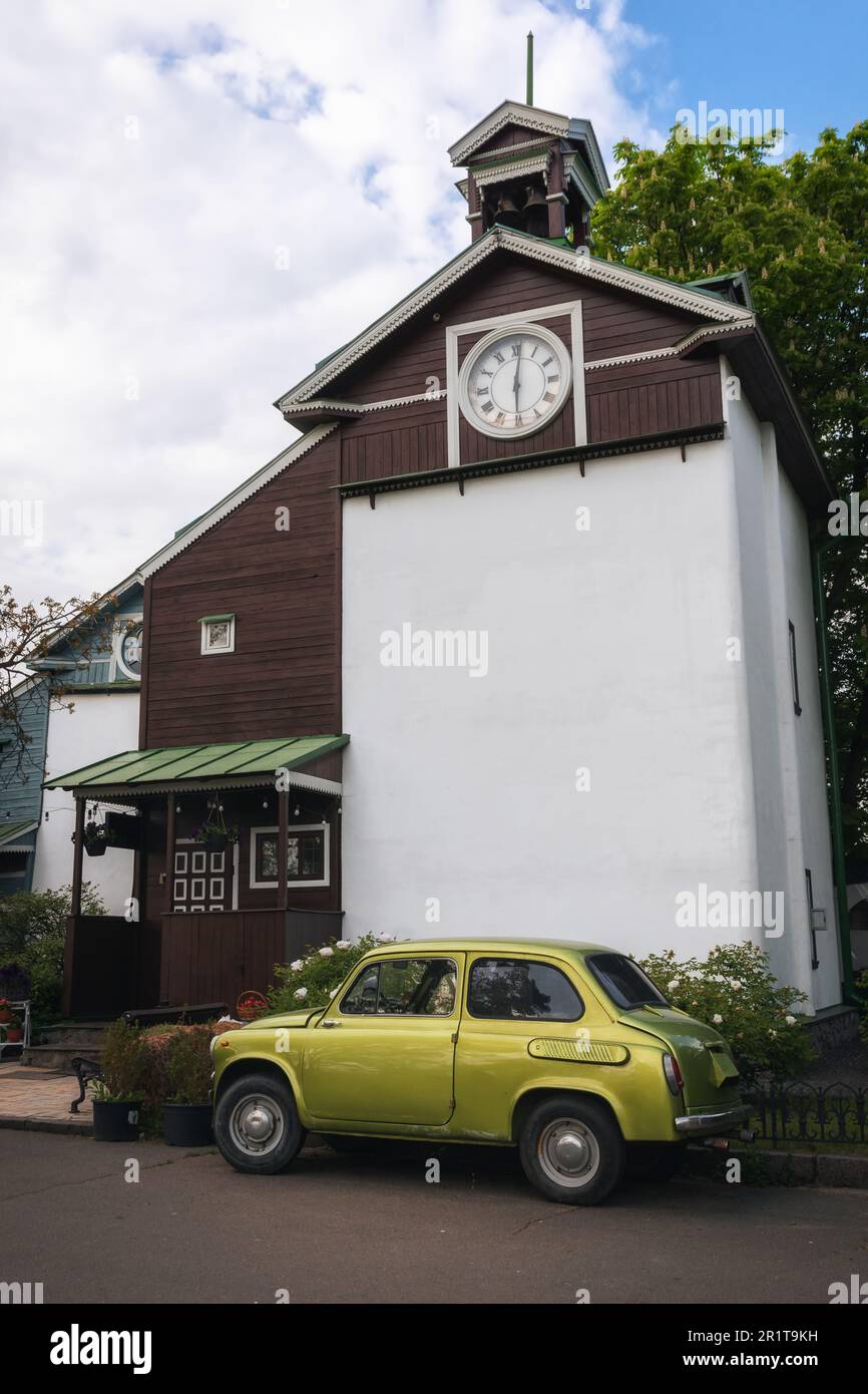 A cozy street of an old town with a clock, a belfry and an old car ...