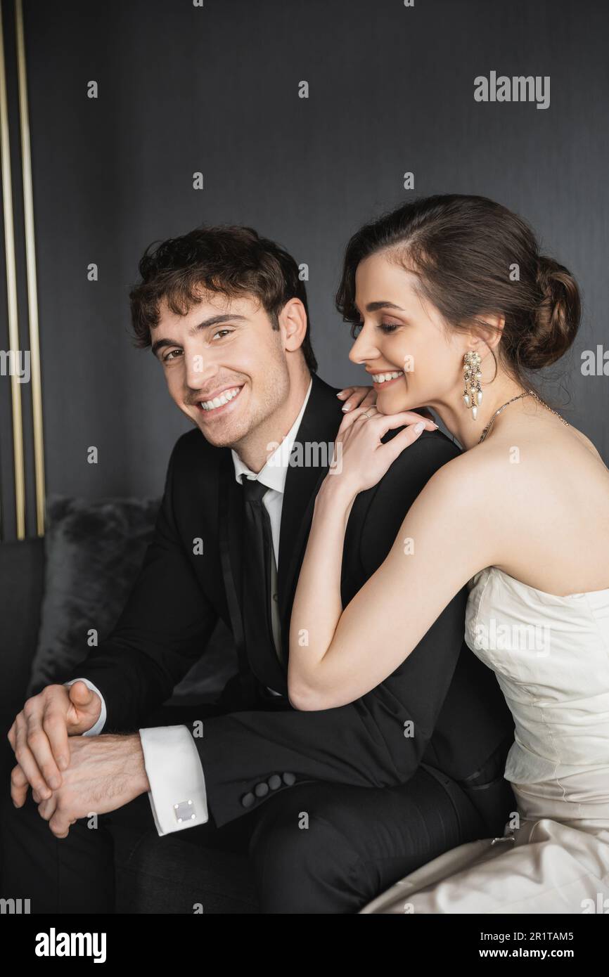 portrait of charming bride in white wedding dress smiling near handsome ...
