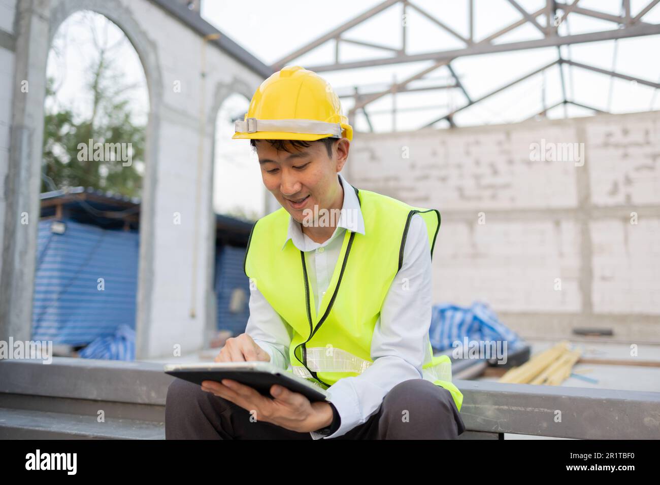 Happy Asian smiling in engineering uniform at construction site while ...