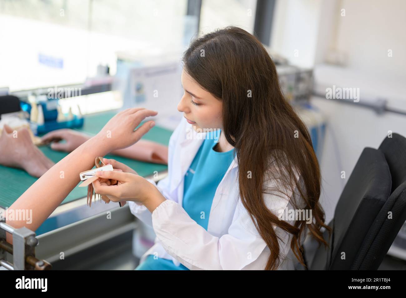 Technician making prosthetic device using grinder to smooth socket ...