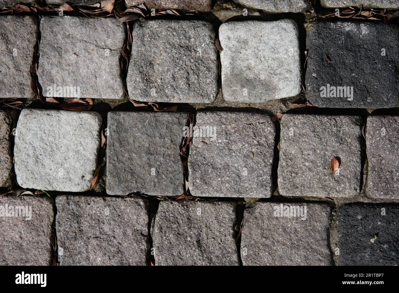 A rustic stone wall comprised of various sizes and colors of stones ...