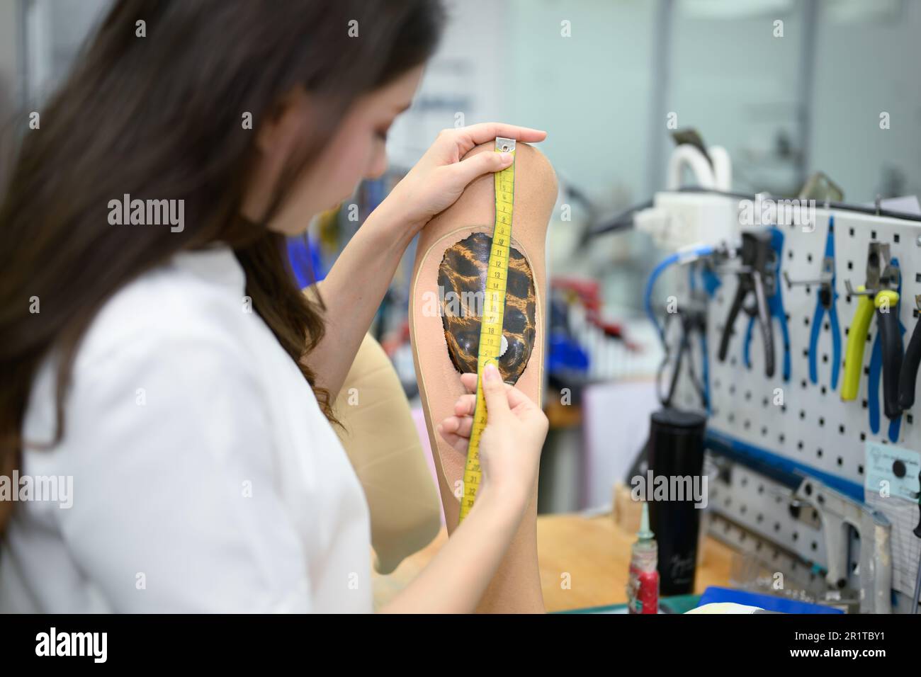 Technician holding prosthetic leg checking and working in laboratory ...