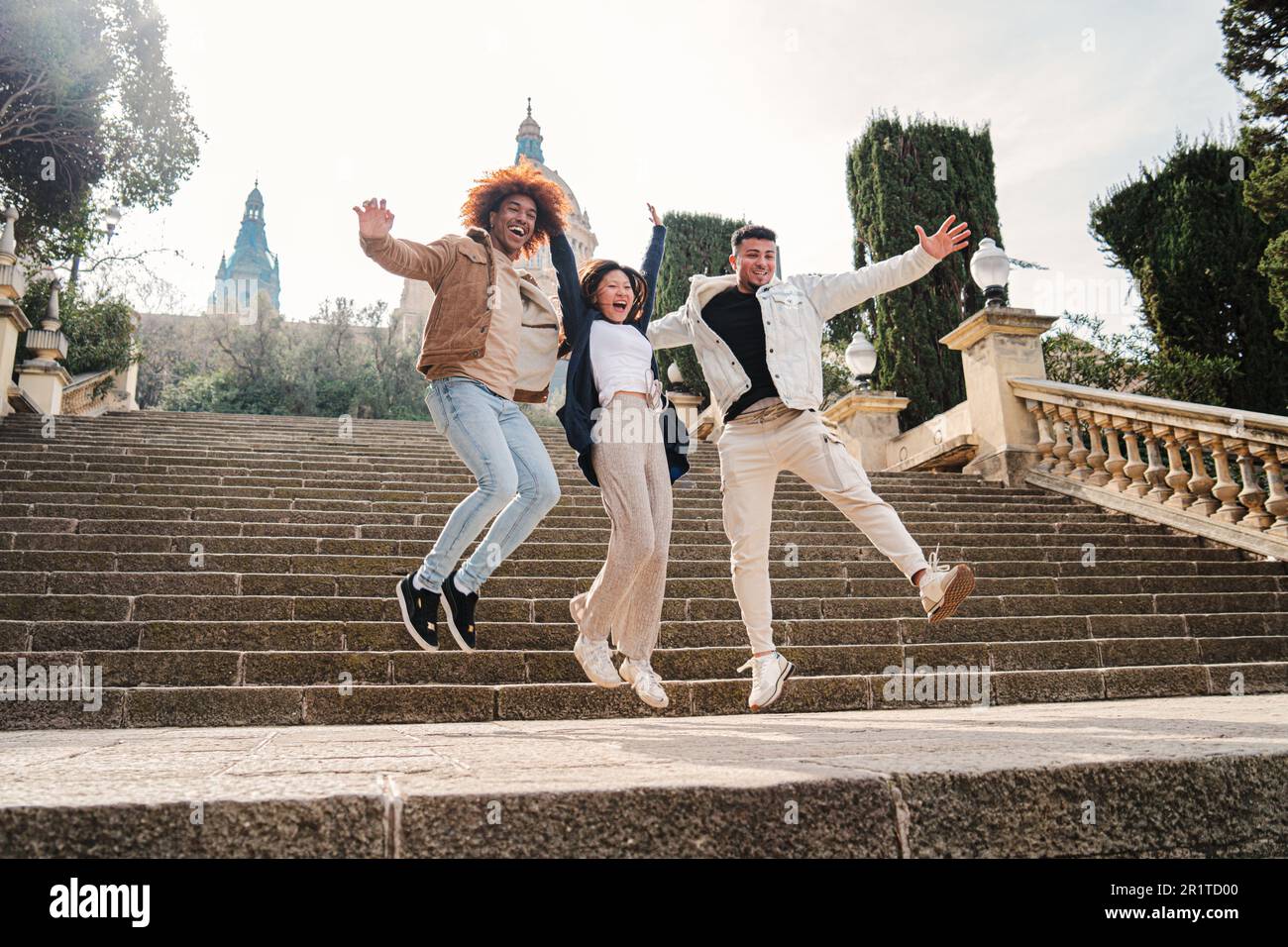 Group of multiracial happy friends having fun jumping on the street ...