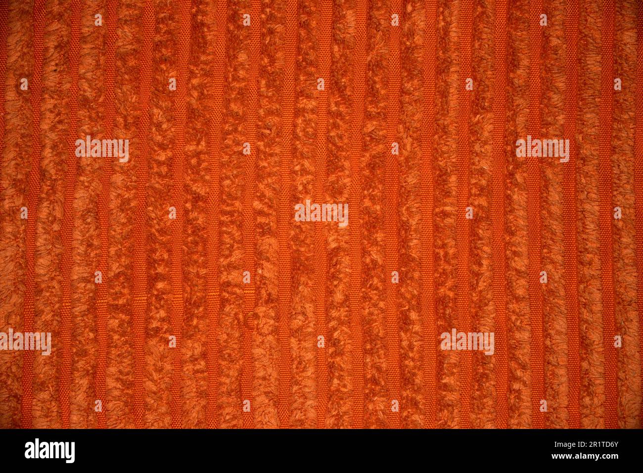 close up of damp orange textured fabric with lines between the low pile ...
