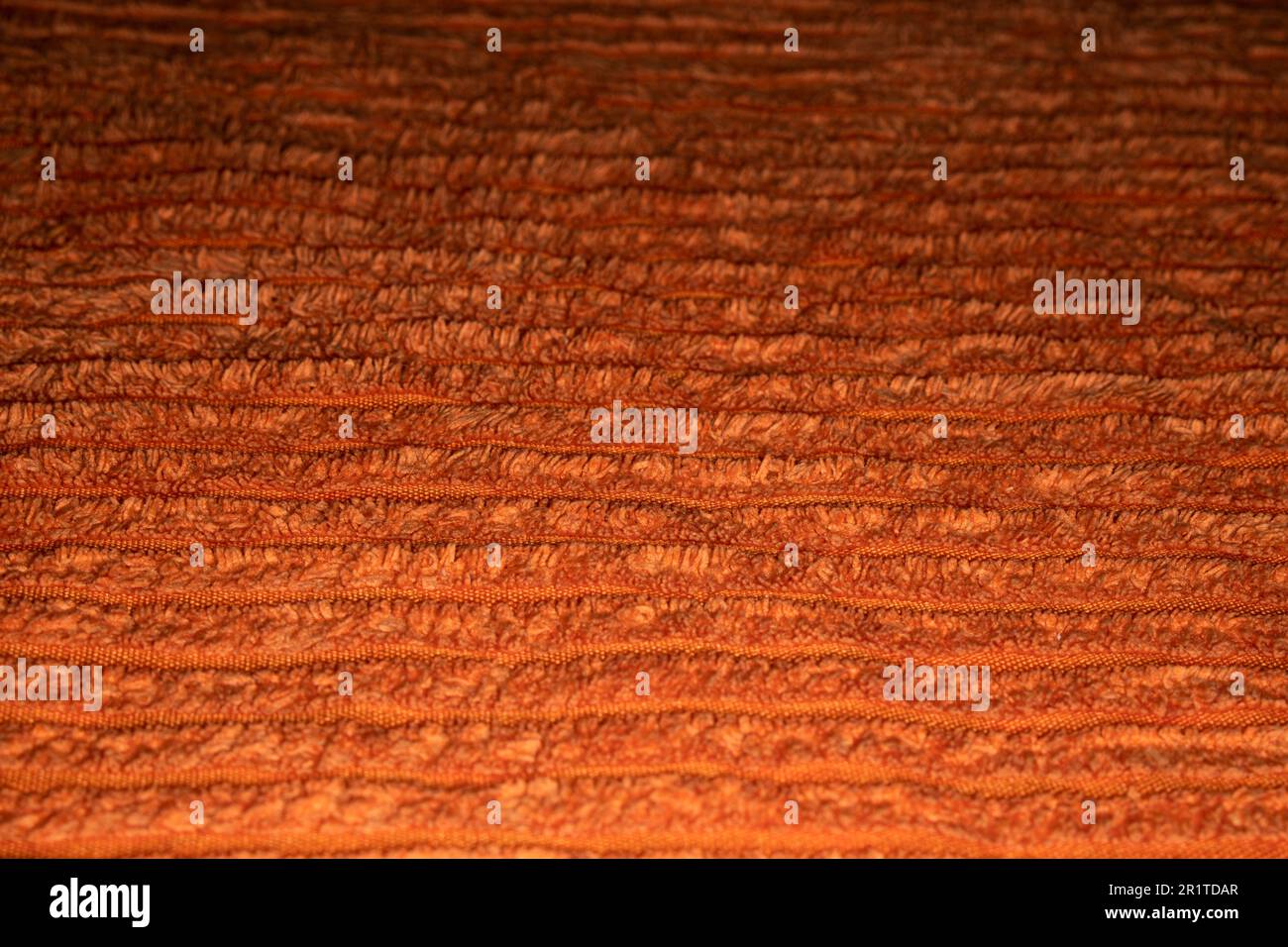 close up of damp orange textured fabric with lines between the low pile ...