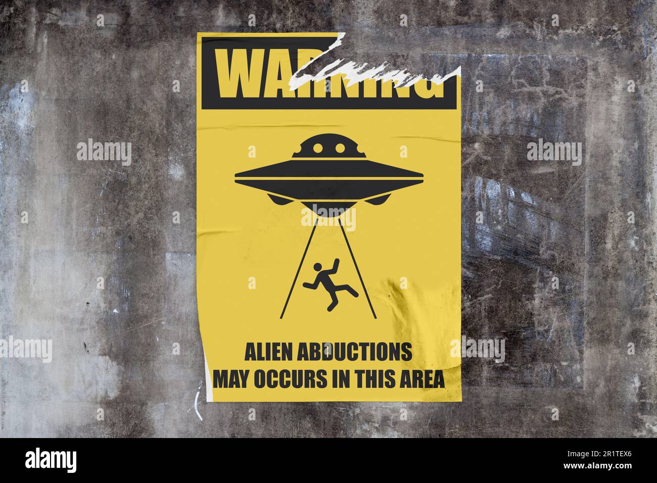 Full-frame weathered concrete wall with a torn yellow poster in the ...