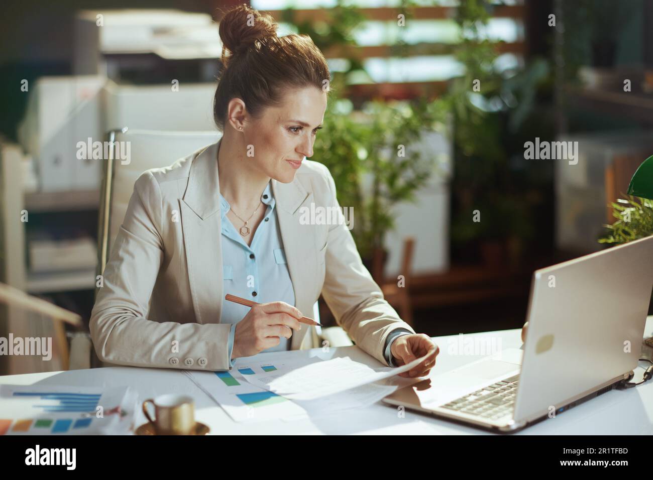 modern accountant woman in a light business suit in modern green office ...