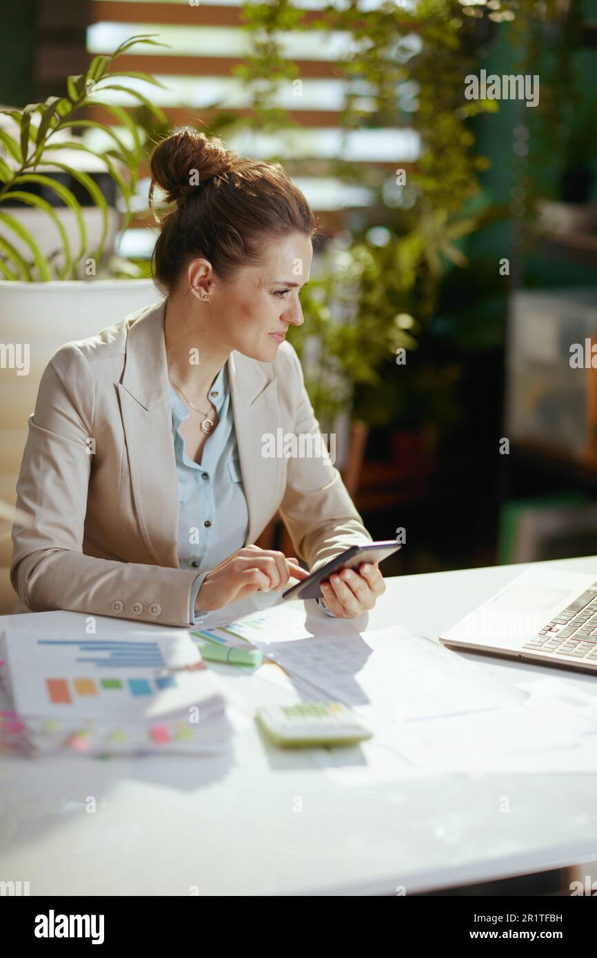 modern bookkeeper woman in a light business suit in modern green office ...