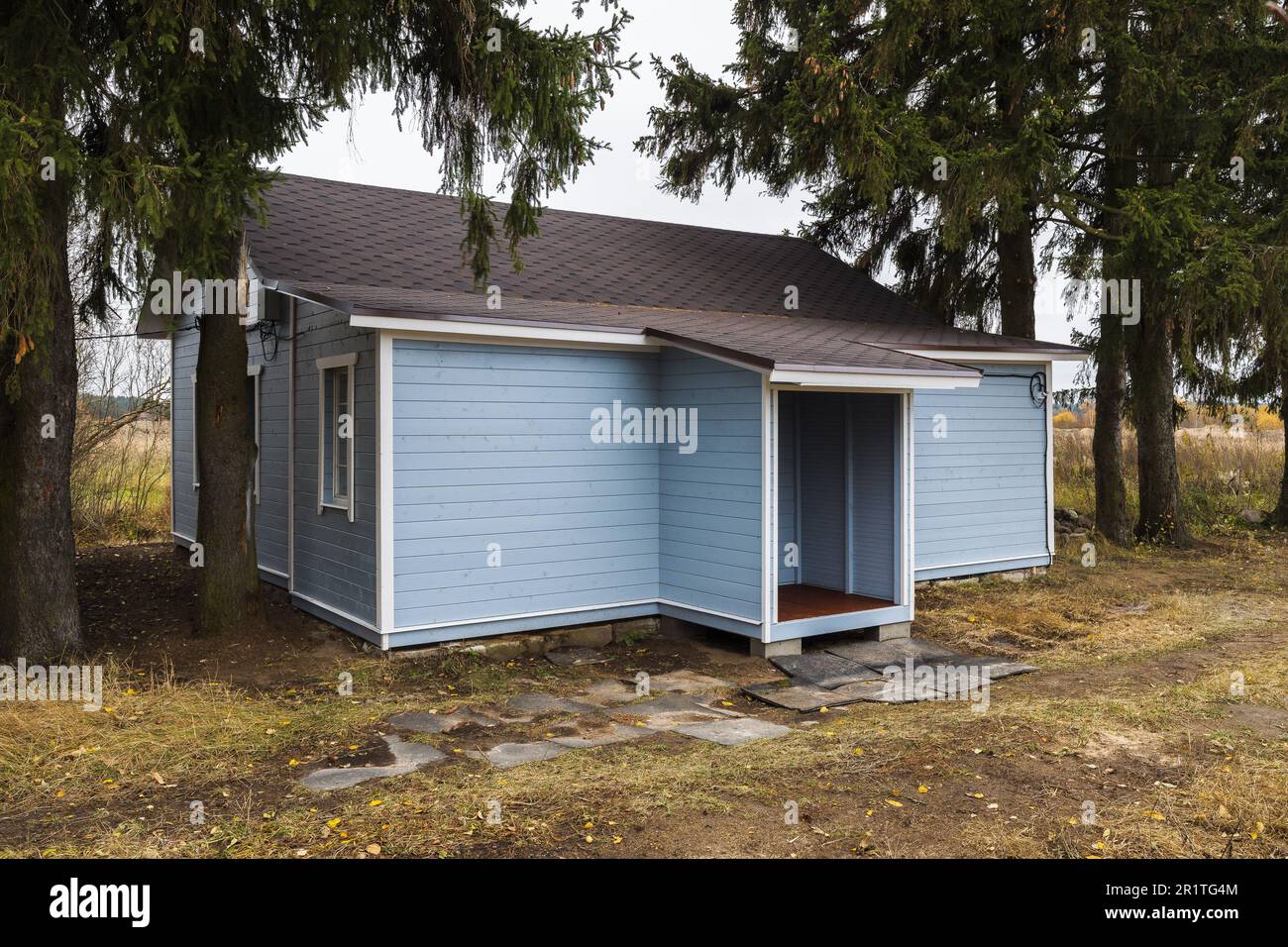 Small cozy blue house in the forest under tree Stock Photo - Alamy
