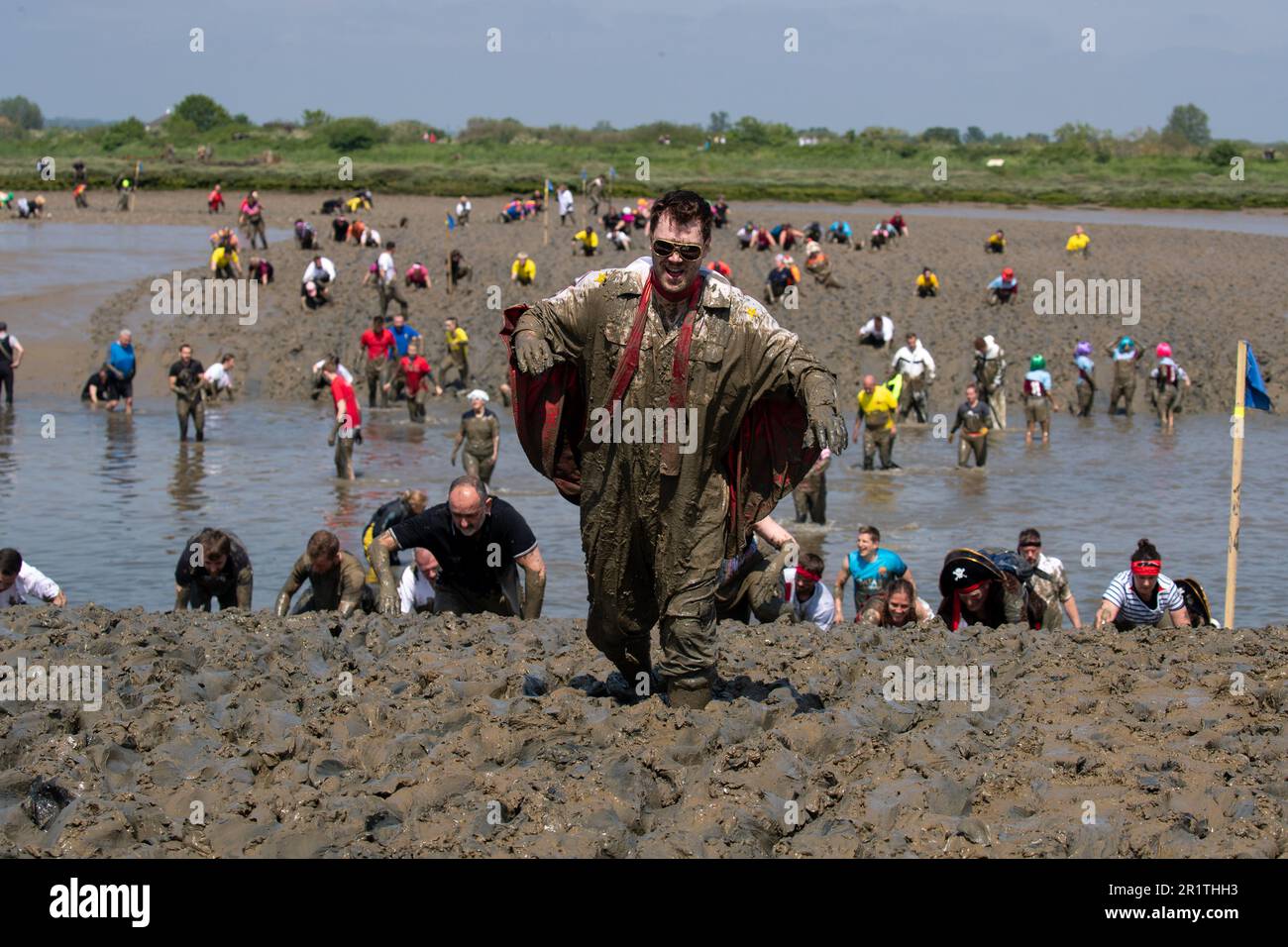 Maldon, UK. 14th May, 2023. A competitor dressed as Elvis takes part in the Maldon Mud Race.The ...