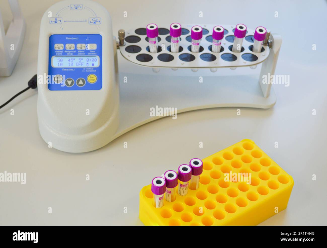 A scientist in a laboratory places test tubes with blood or urine in ...