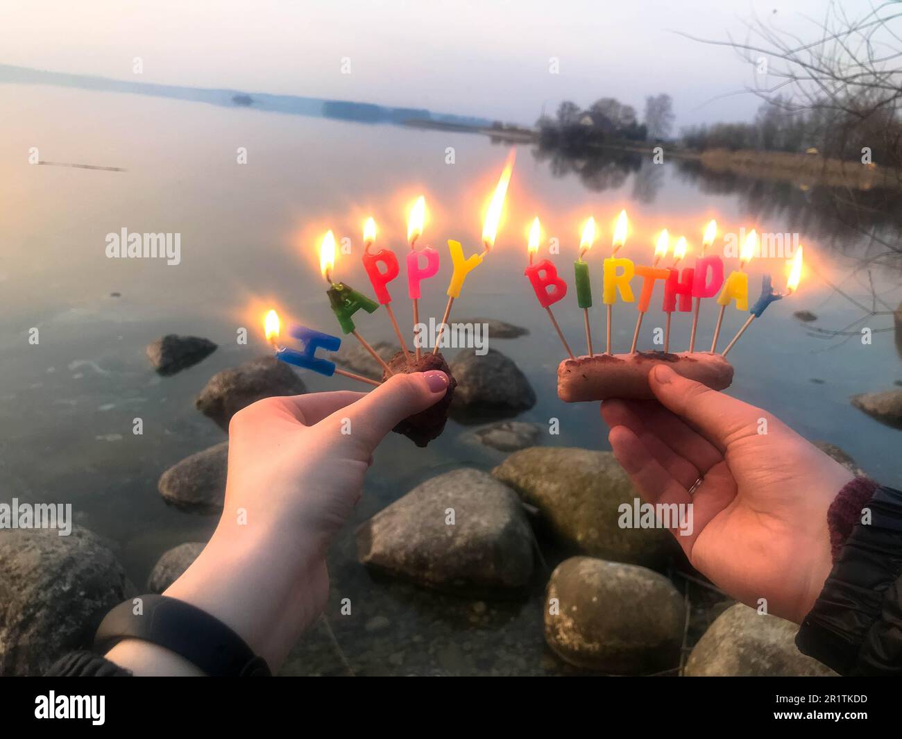 Burning happy birthday inscription made of holiday candles in the hands ...