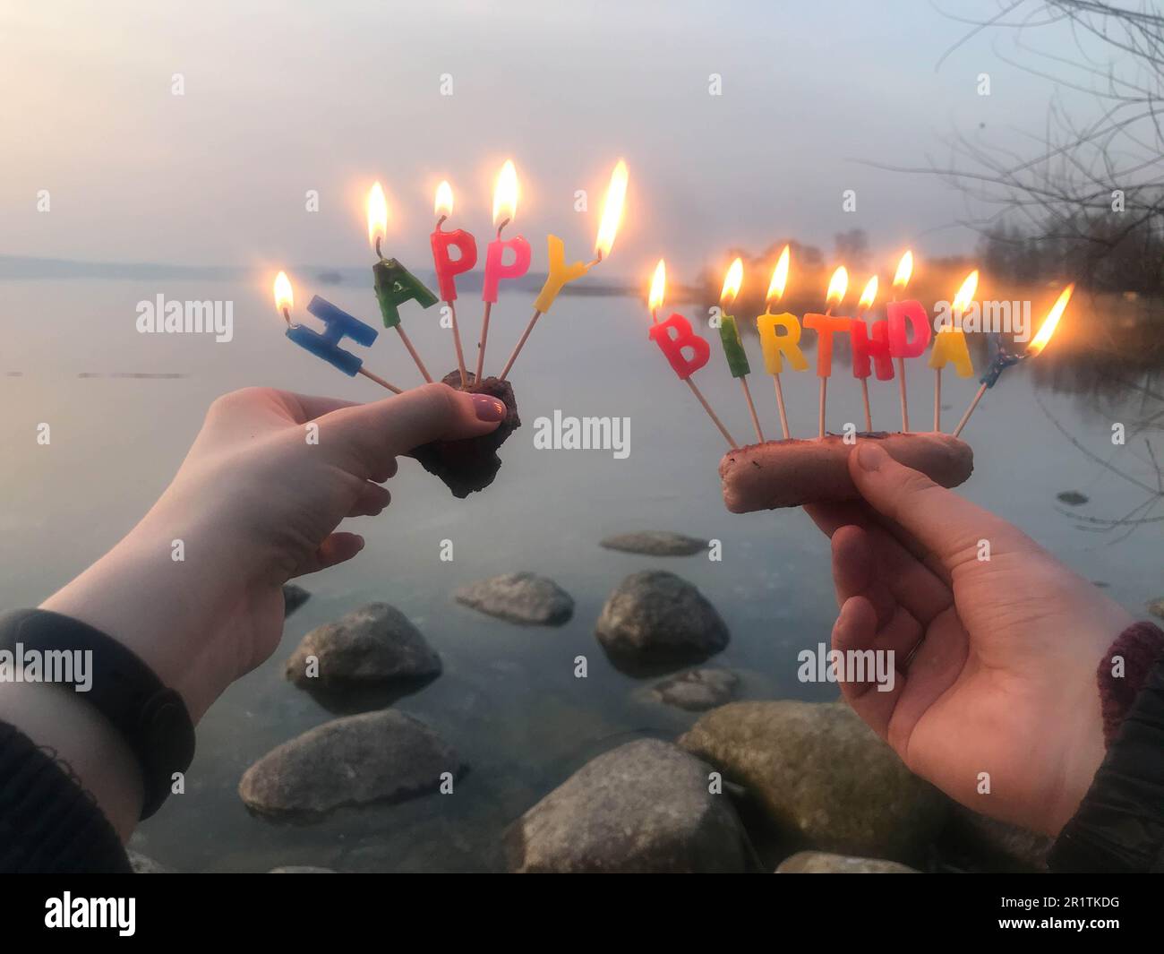 Burning happy birthday inscription made of holiday candles in the hands ...