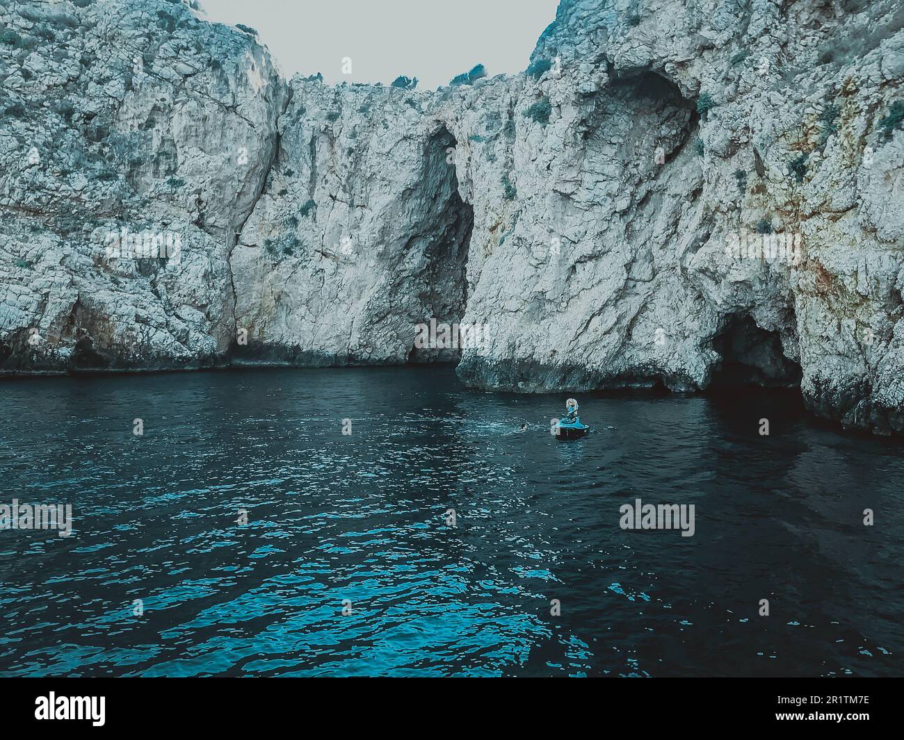 mountain in the sea. blue expanse of water. a mountain of sand, stones ...