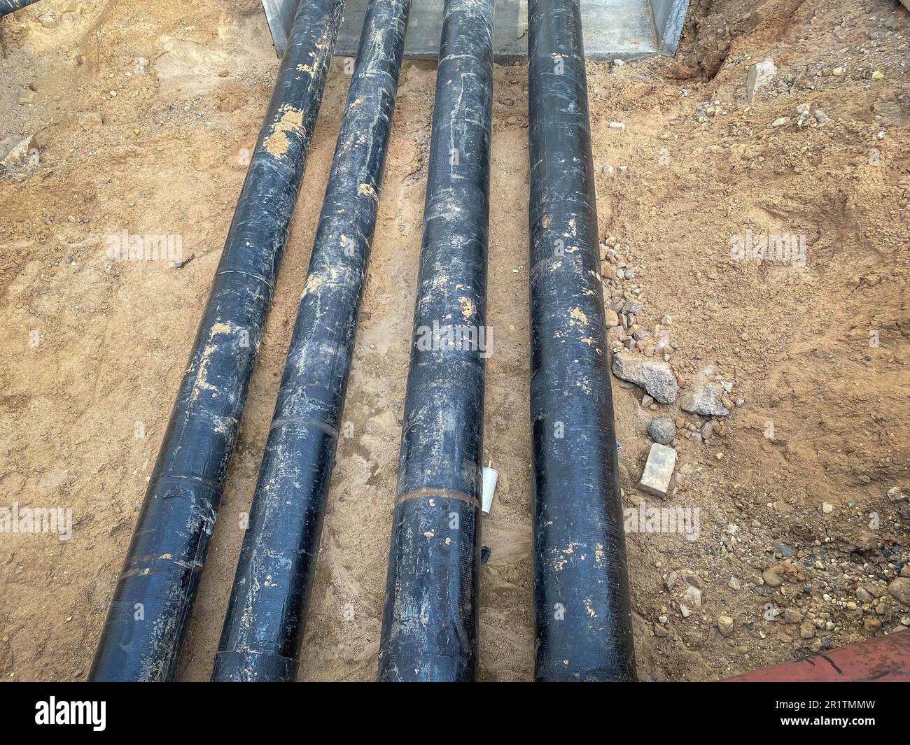 construction of a new neighborhood in the city. black long pipes are ...