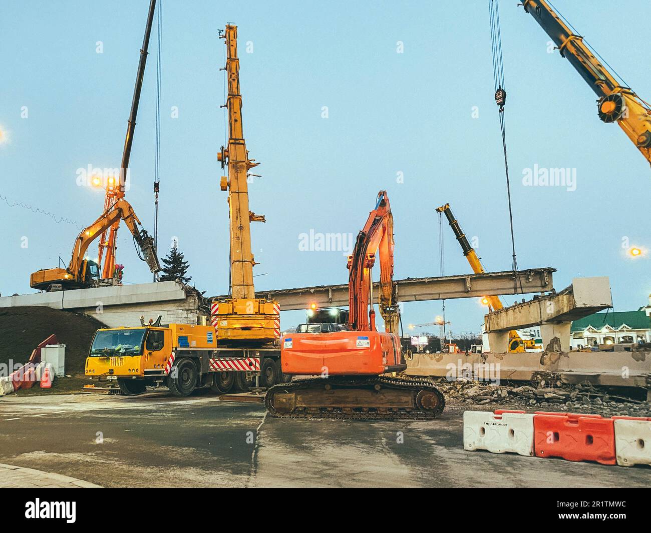 construction of a broken bridge on a busy road. the crane carries large ...