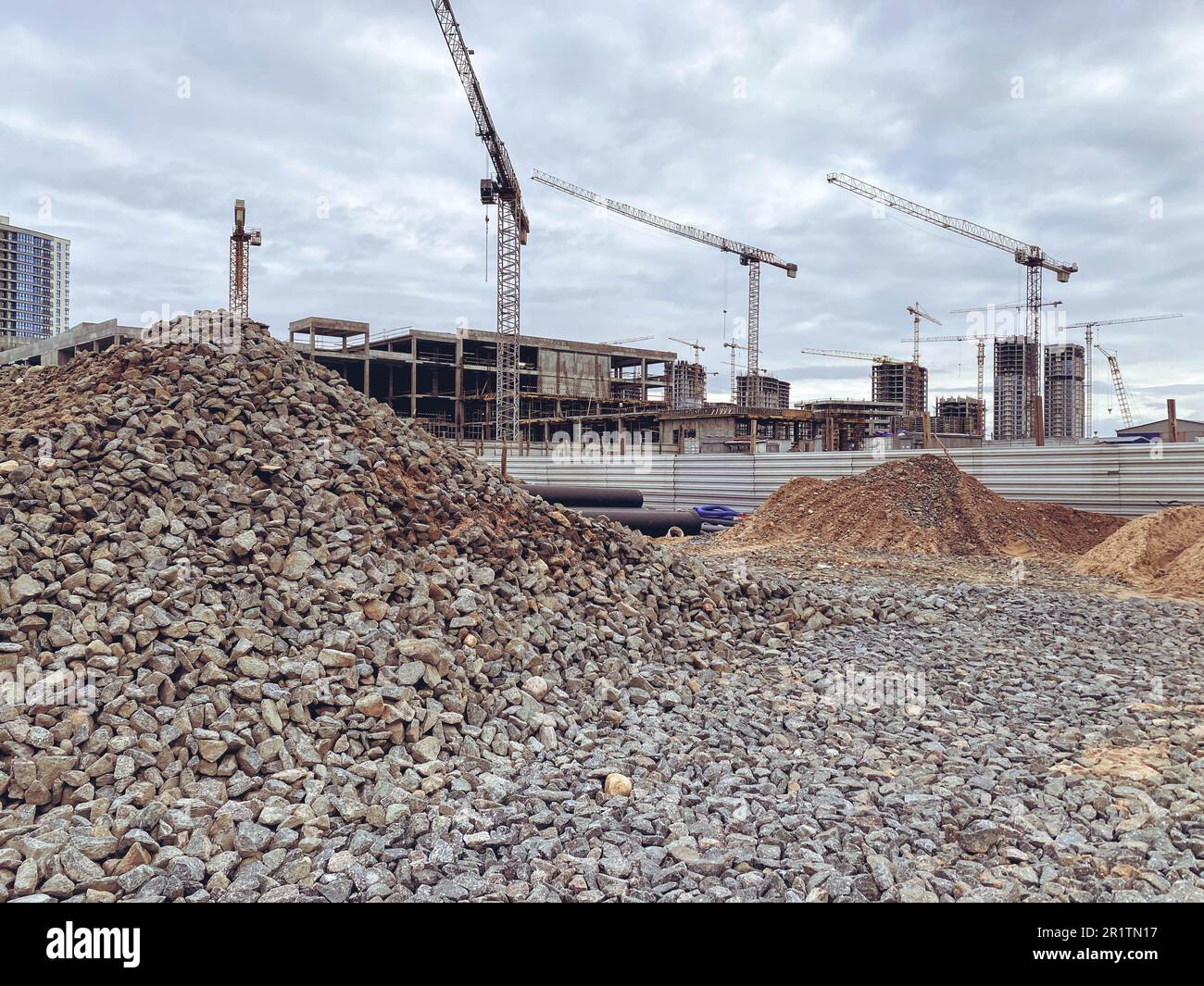 construction of high houses in the city. cranes pull heavy concrete ...